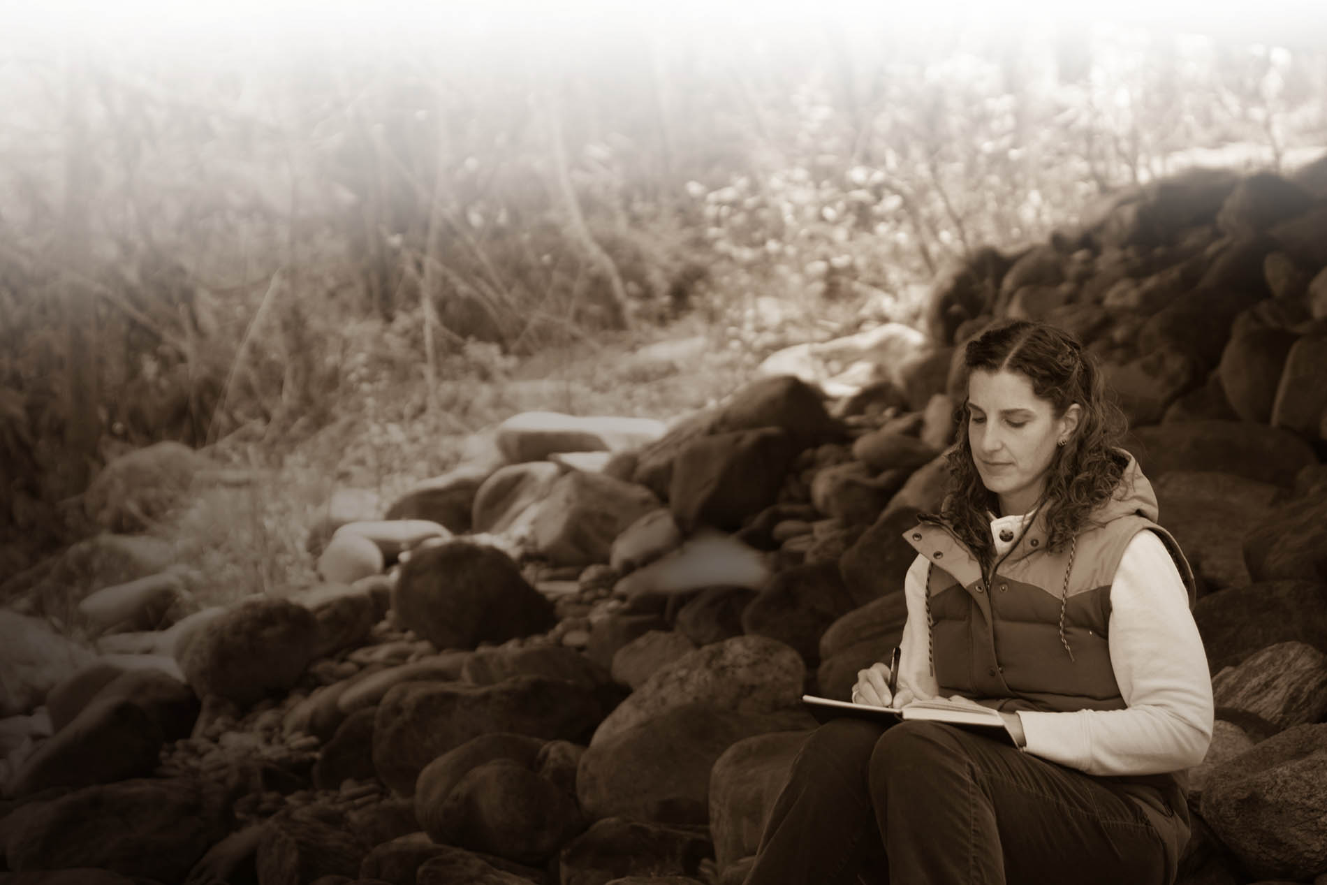 Katey writing by rocks - Katey Schultz